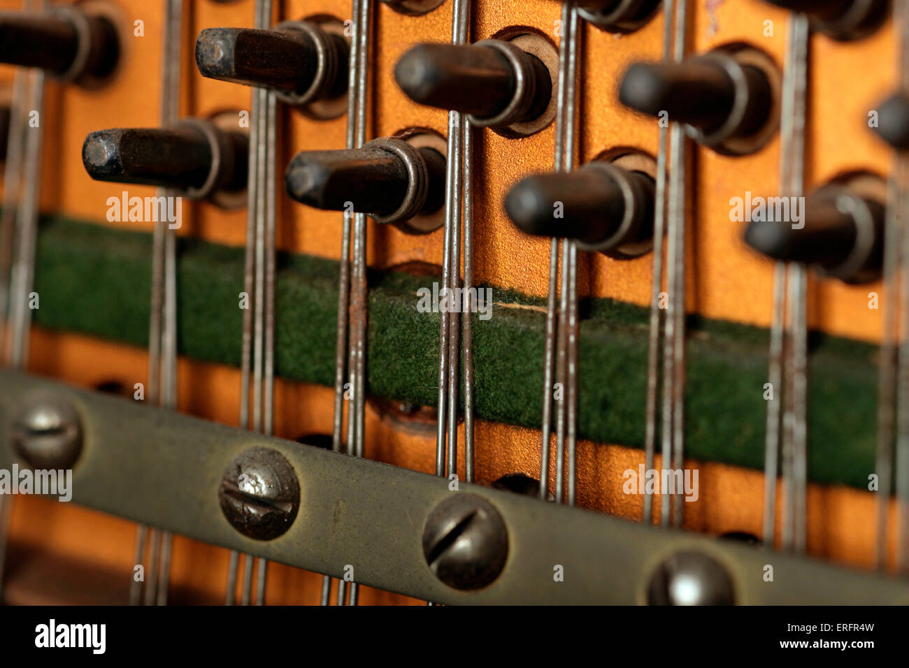 Close-up detail of piano - pegs or pins and strings from an upright ...