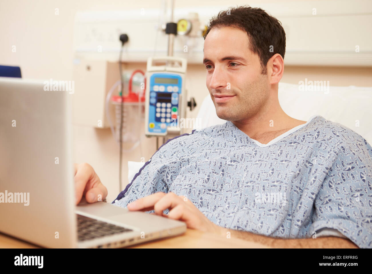 Male Patient Using Laptop In Hospital Bed Stock Photo - Alamy