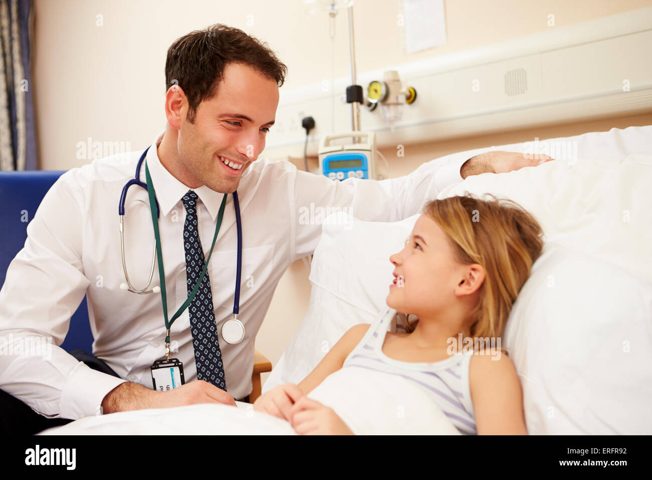 Doctor Sitting By Young Girl's Bed In Hospital Stock Photo - Alamy