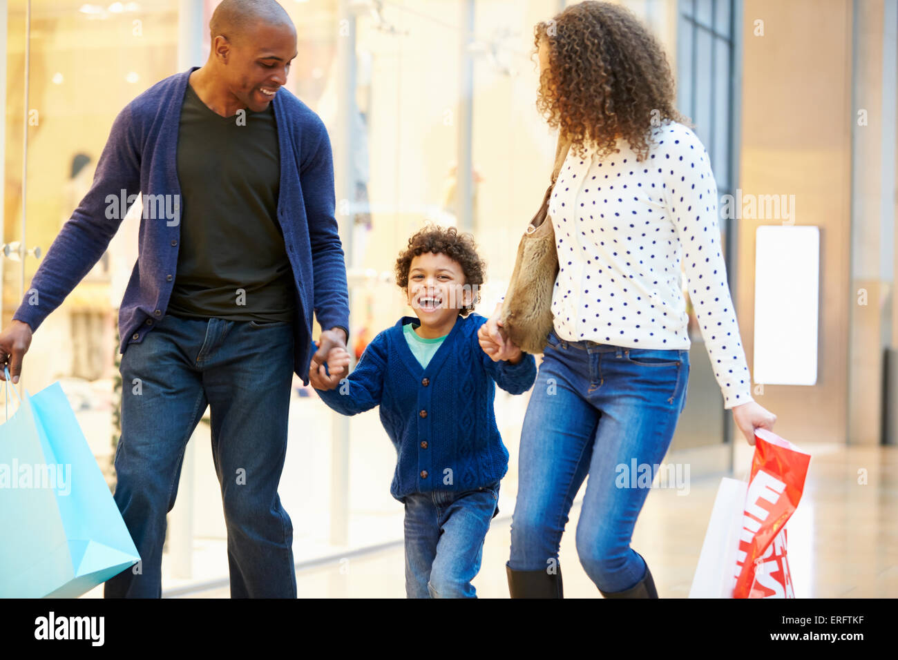 Child On Trip To Shopping Mall With Parents Stock Photo - Alamy
