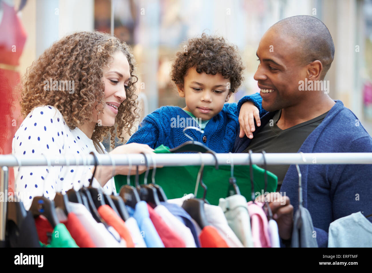 Family Looking At Clothes On Rail In Shopping Mall Stock Photo - Alamy