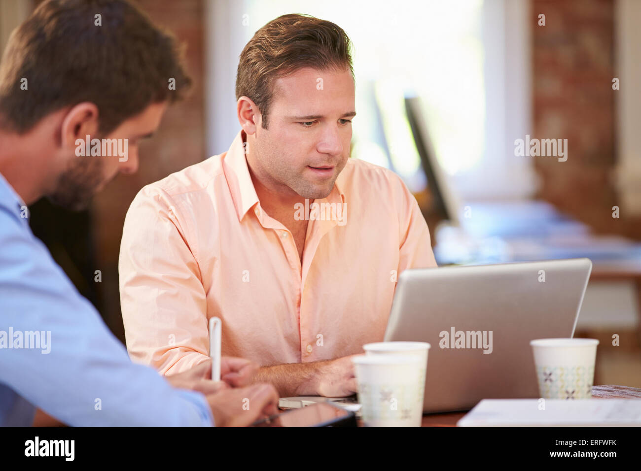 Two Businessmen Working At Desk Together Stock Photo - Alamy