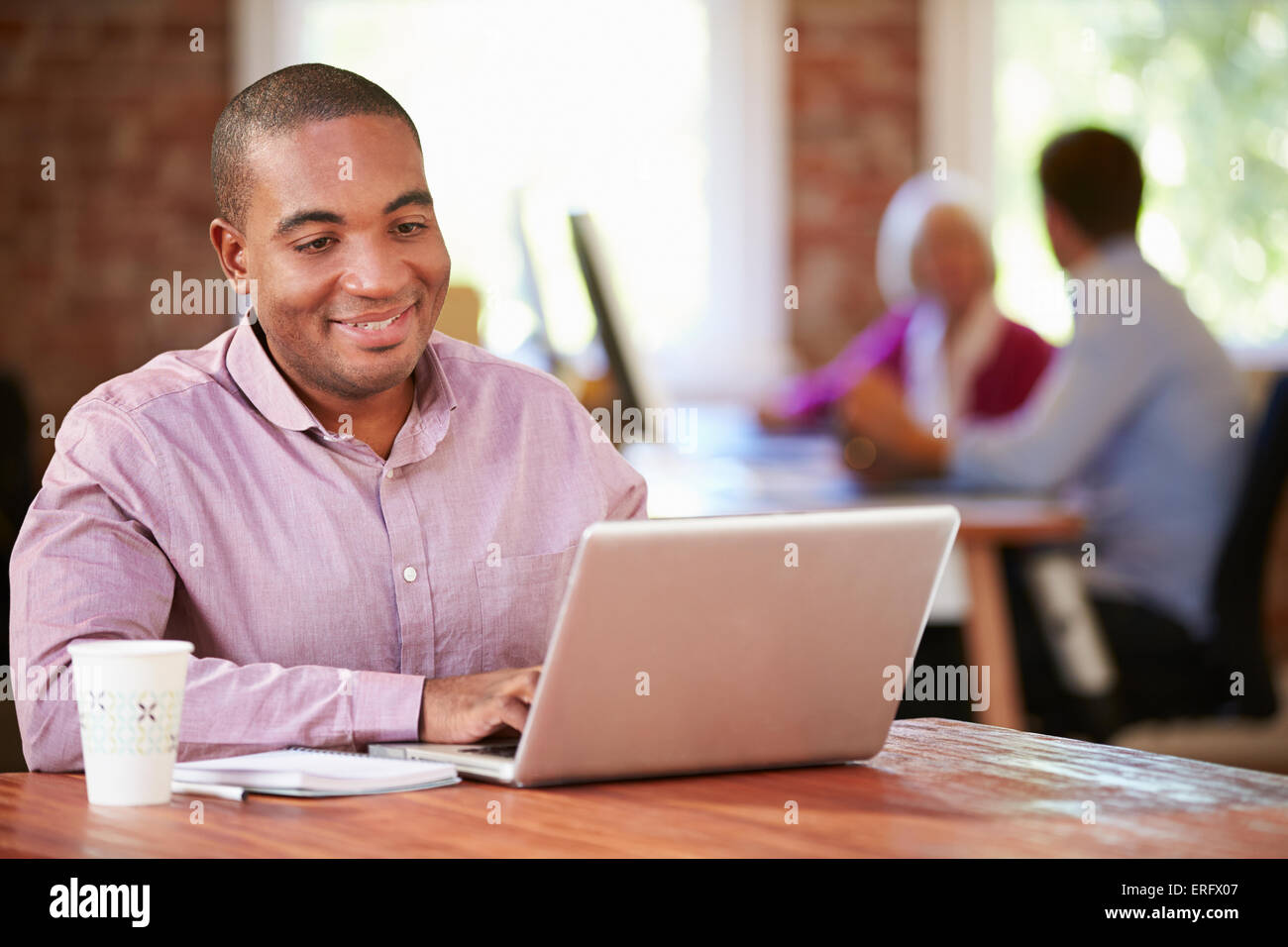 Man Working At Laptop In Contemporary Office Stock Photo - Alamy