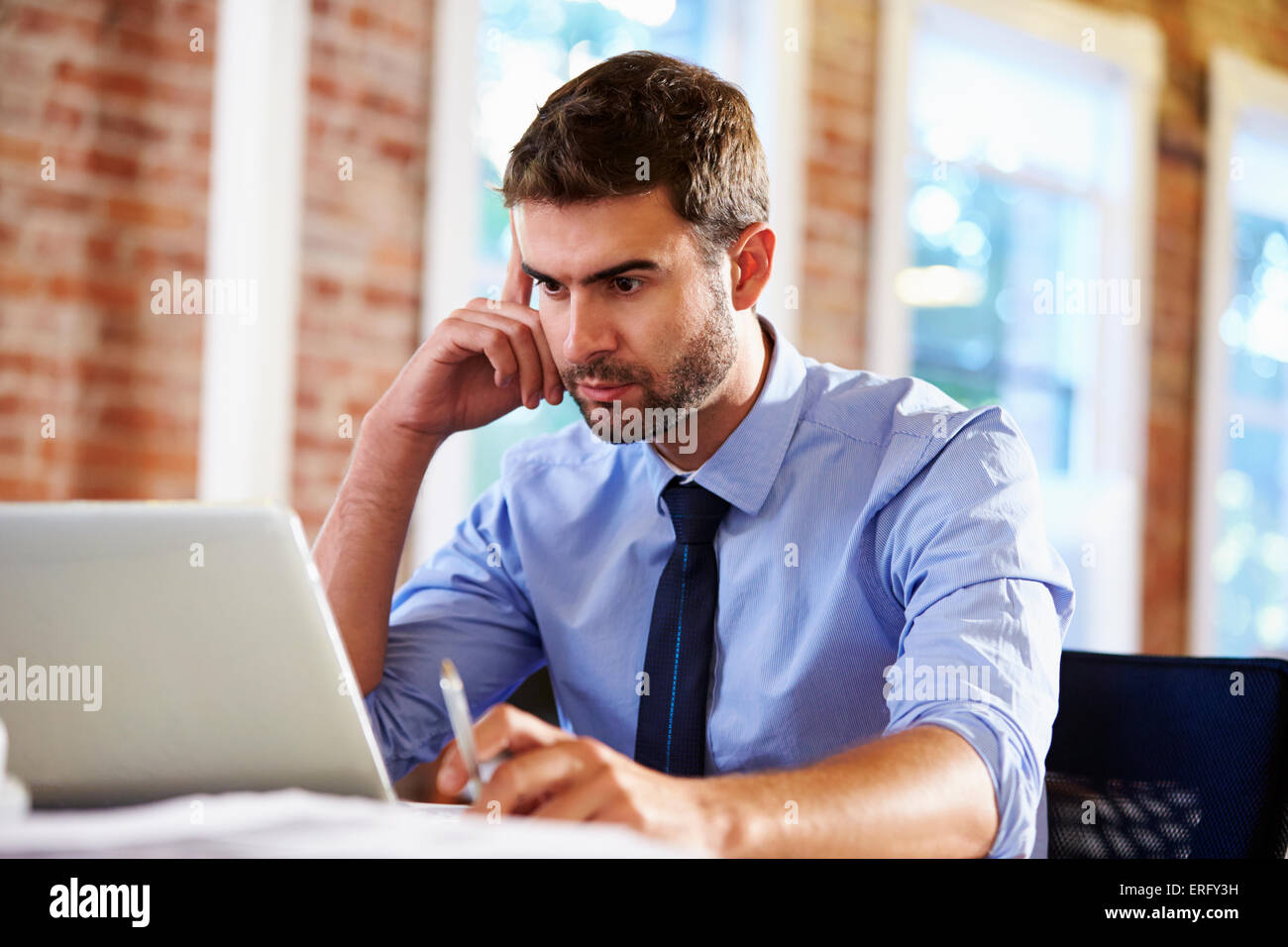 Man Working At Laptop In Contemporary Office Stock Photo - Alamy
