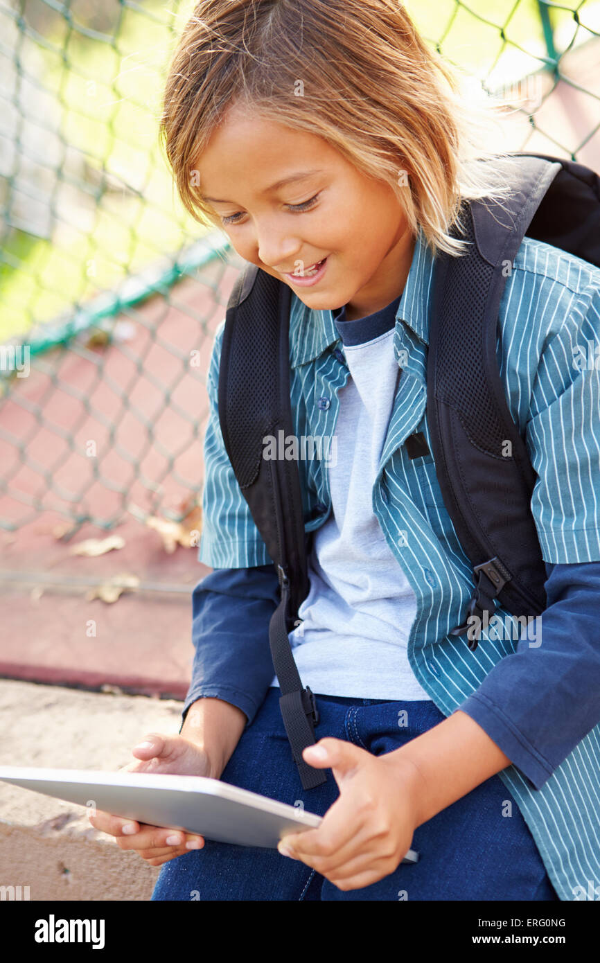 Young Boy Using Digital Tablet Sitting In Park Stock Photo - Alamy