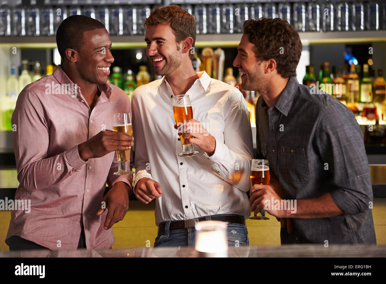 Three Male Friends Enjoying Drink At Bar Stock Photo - Alamy