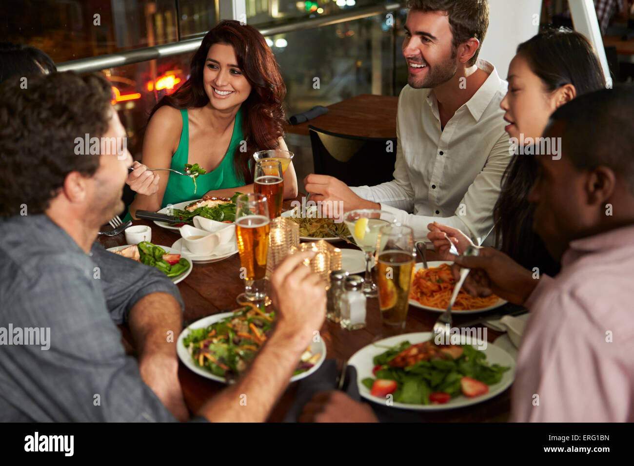 Group Of Friends Enjoying Evening Meal In Restaurant Stock Photo - Alamy