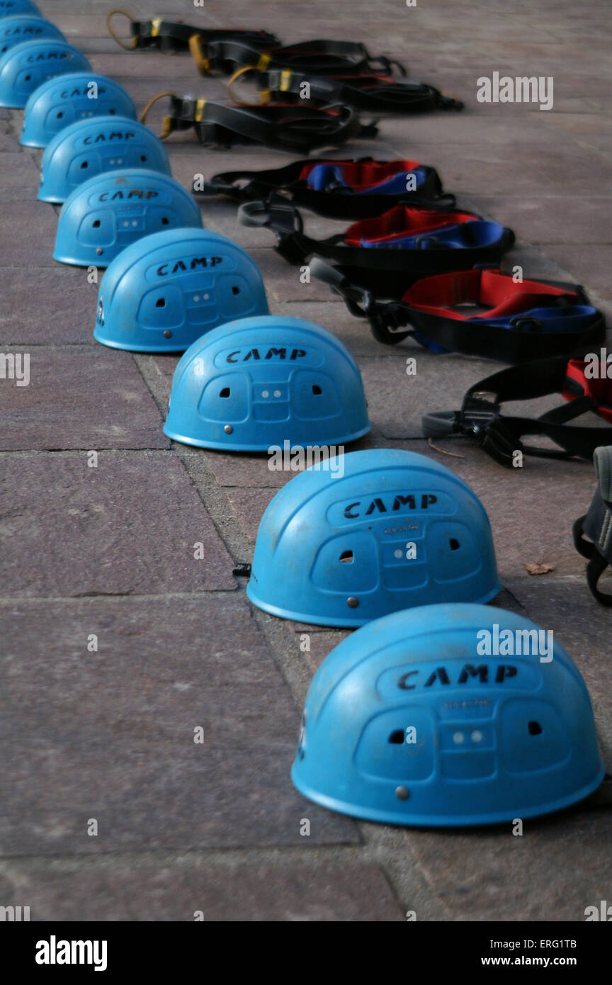A row of blue plastic climbing helmets and harnesses Stock Photo - Alamy