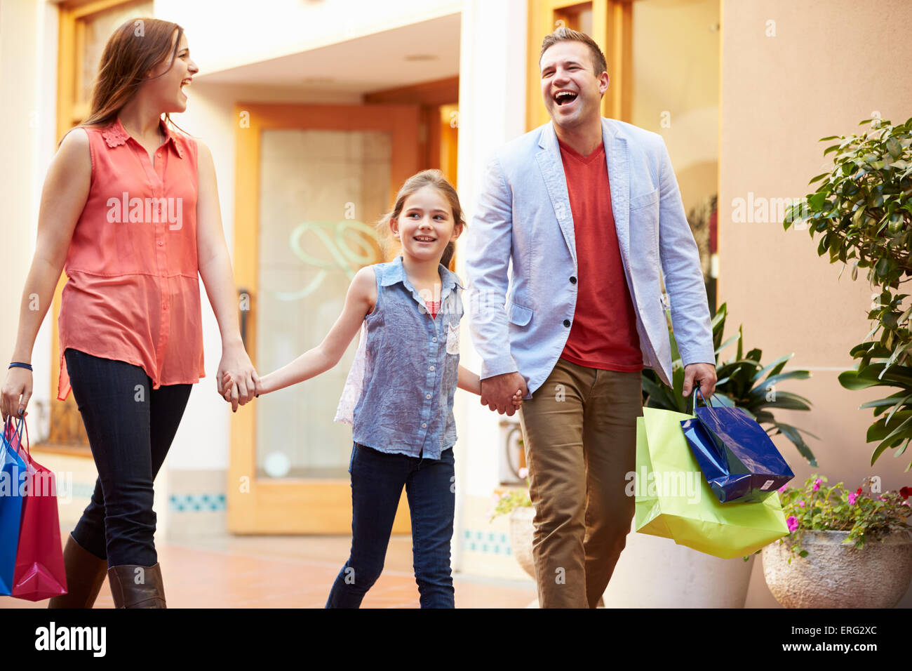 Family Walking Through Mall With Shopping Bags Stock Photo - Alamy
