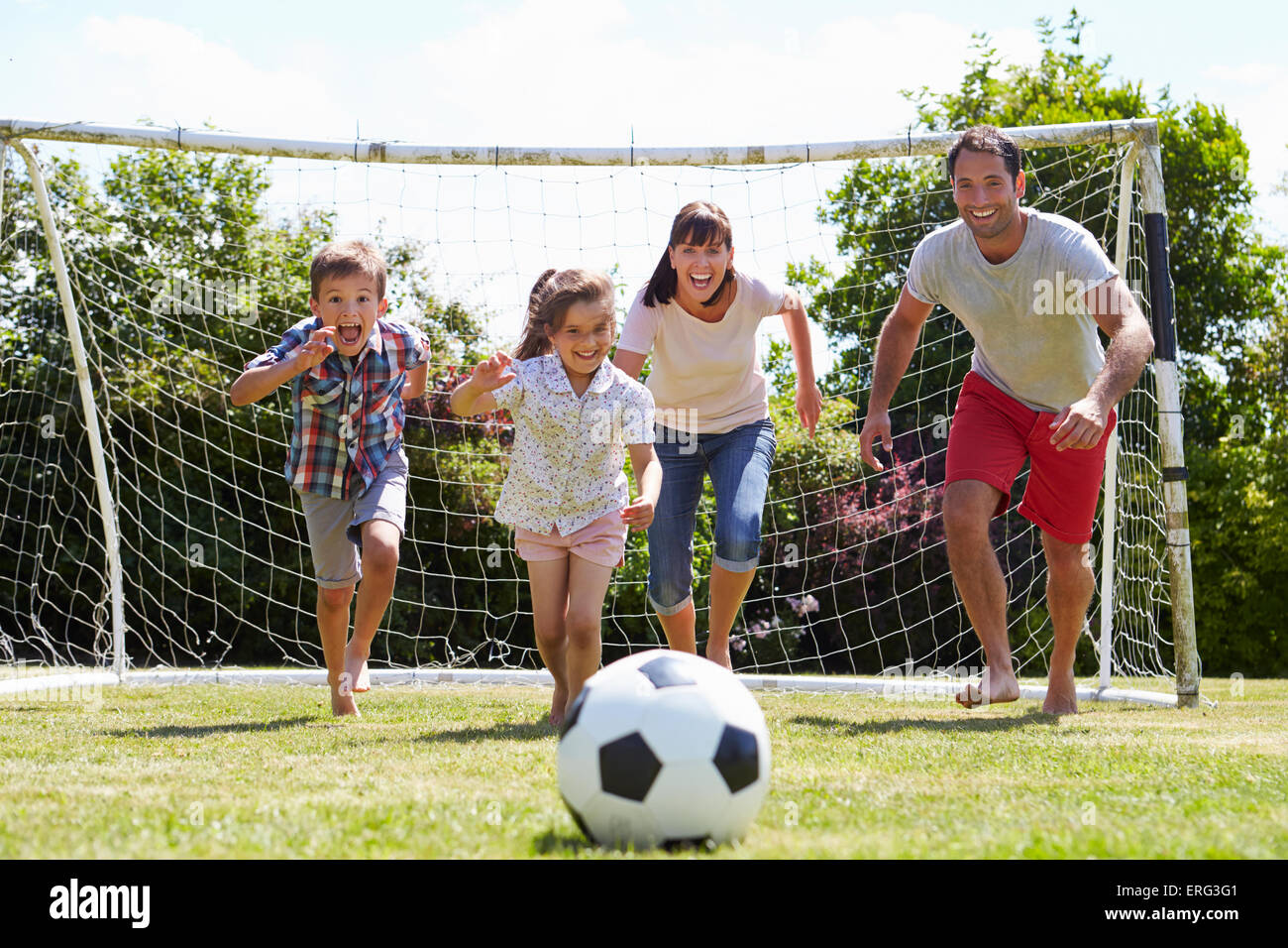 Family Playing Football In Garden Together Stock Photo - Alamy