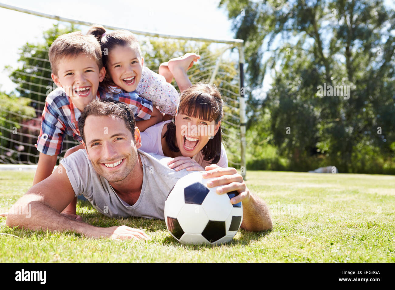 Family Playing Football In Garden Together Stock Photo - Alamy