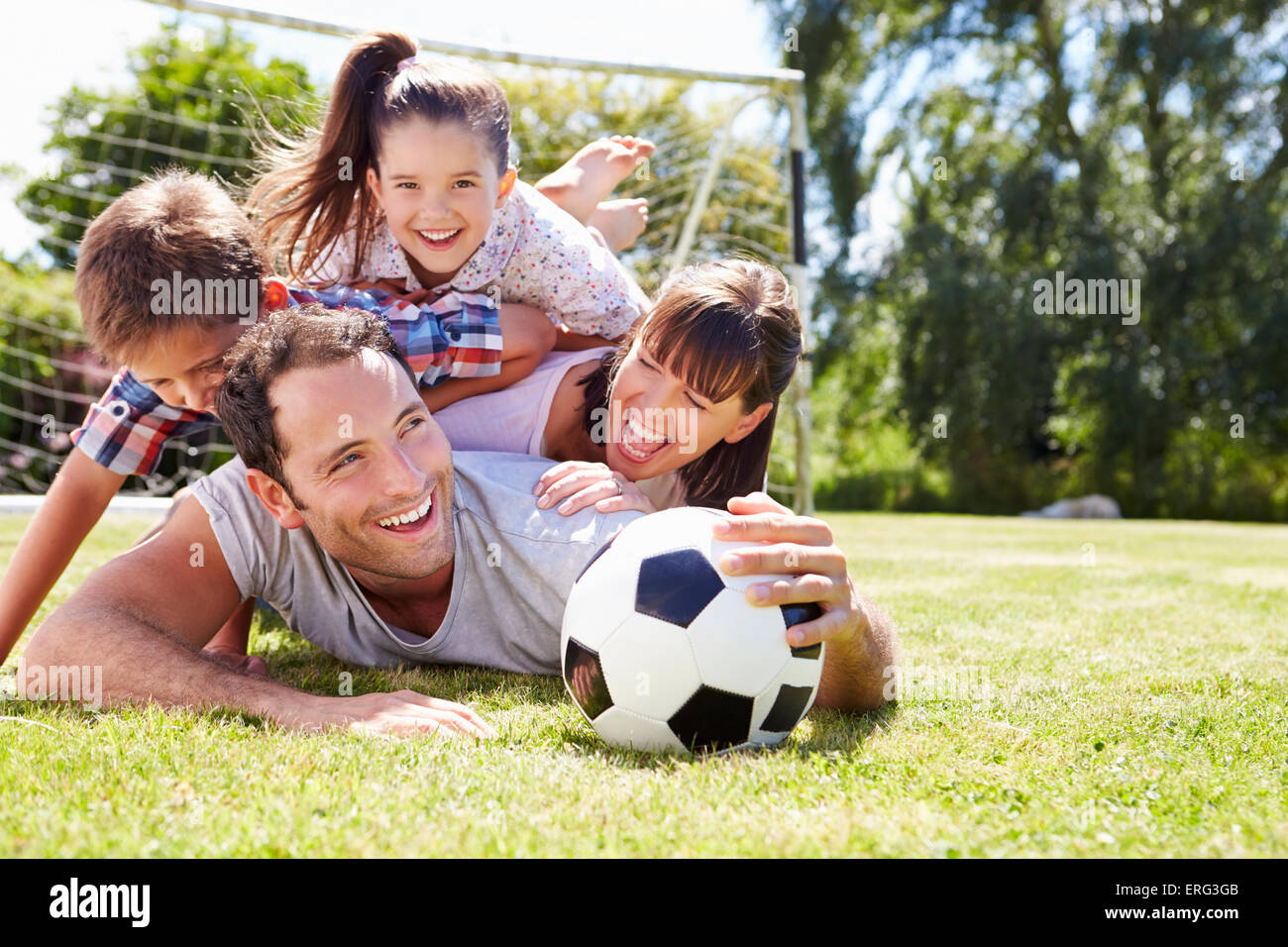 Family Playing Football In Garden Together Stock Photo - Alamy