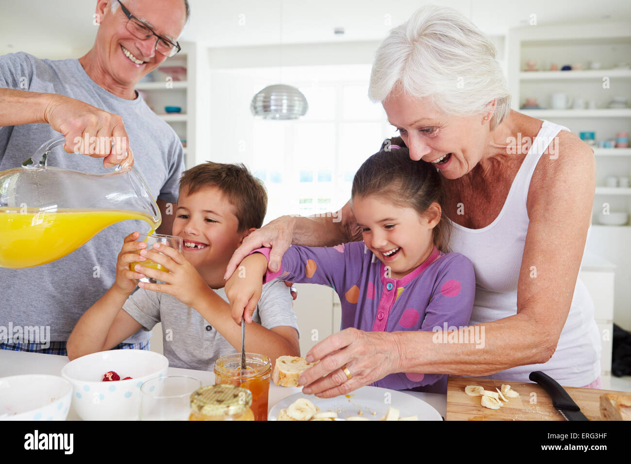 Grandparents With Grandchildren Making Breakfast In Kitchen Stock Photo ...