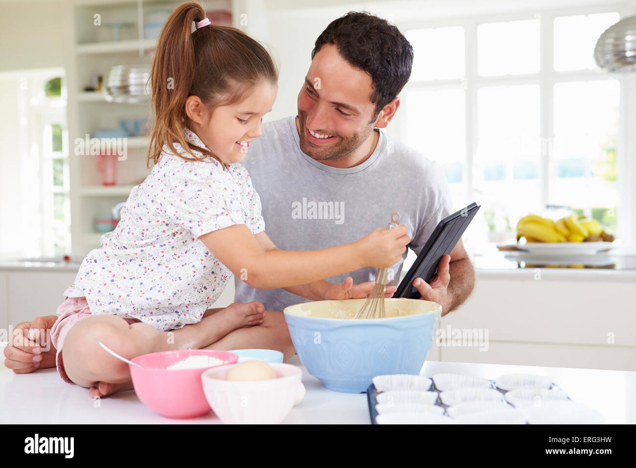 Father And Daughter Following Cake Recipe On Digital tablet Stock Photo ...