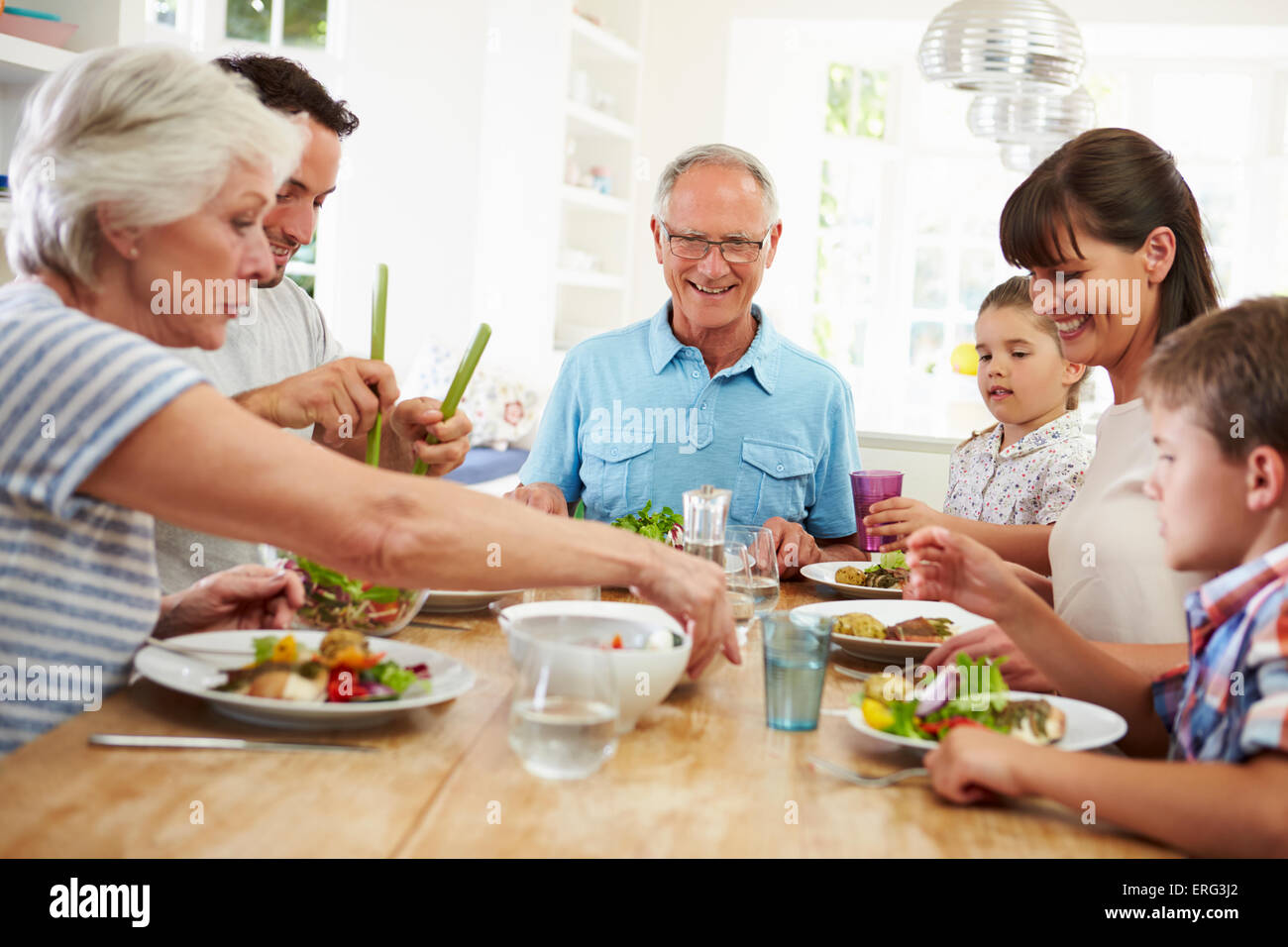 Multi Generation Family Eating Meal Around Kitchen Table Stock Photo ...