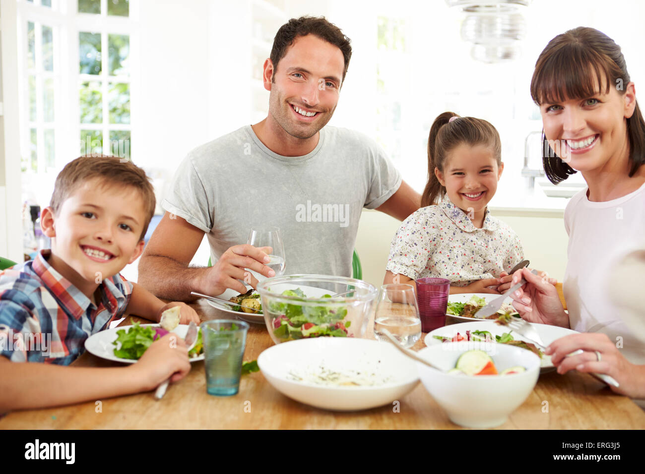 Family Eating Meal Around Kitchen Table Together Stock Photo - Alamy