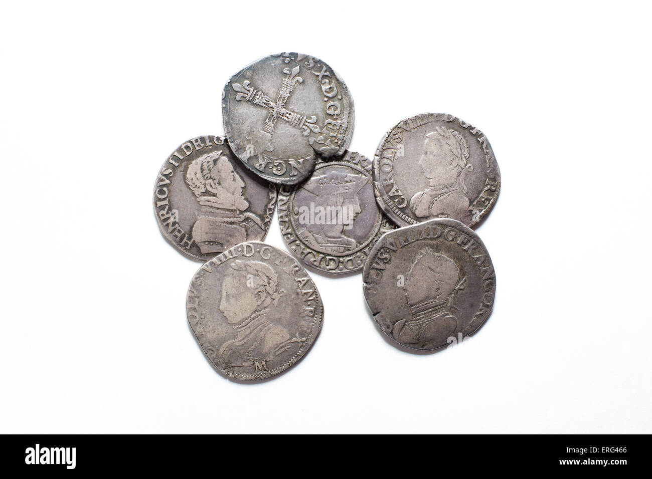 A lot of old silver coins with portraits of kings on a white background ...