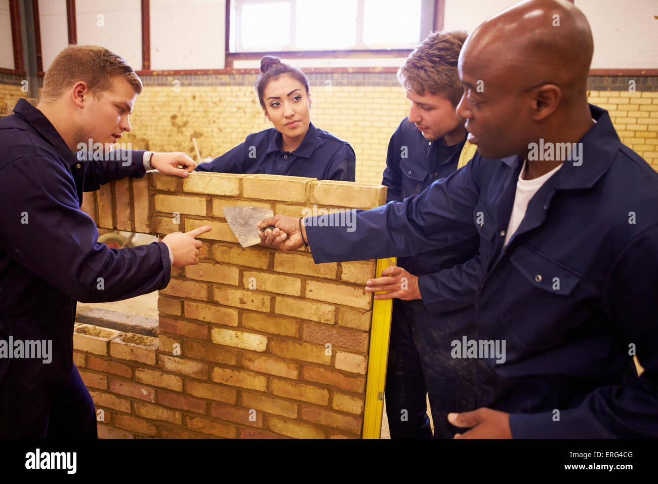 Teacher Helping Students Training To Be Builders Stock Photo - Alamy