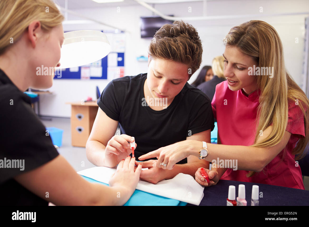 Teacher Helping Students Training To Become Beauticians Stock Photo - Alamy