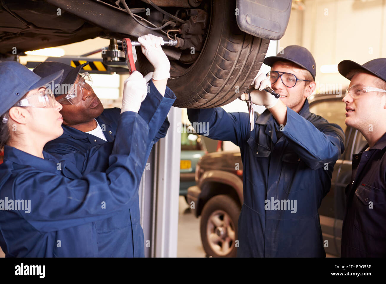 Teacher Helping Students Training To Be Car Mechanics Stock Photo - Alamy