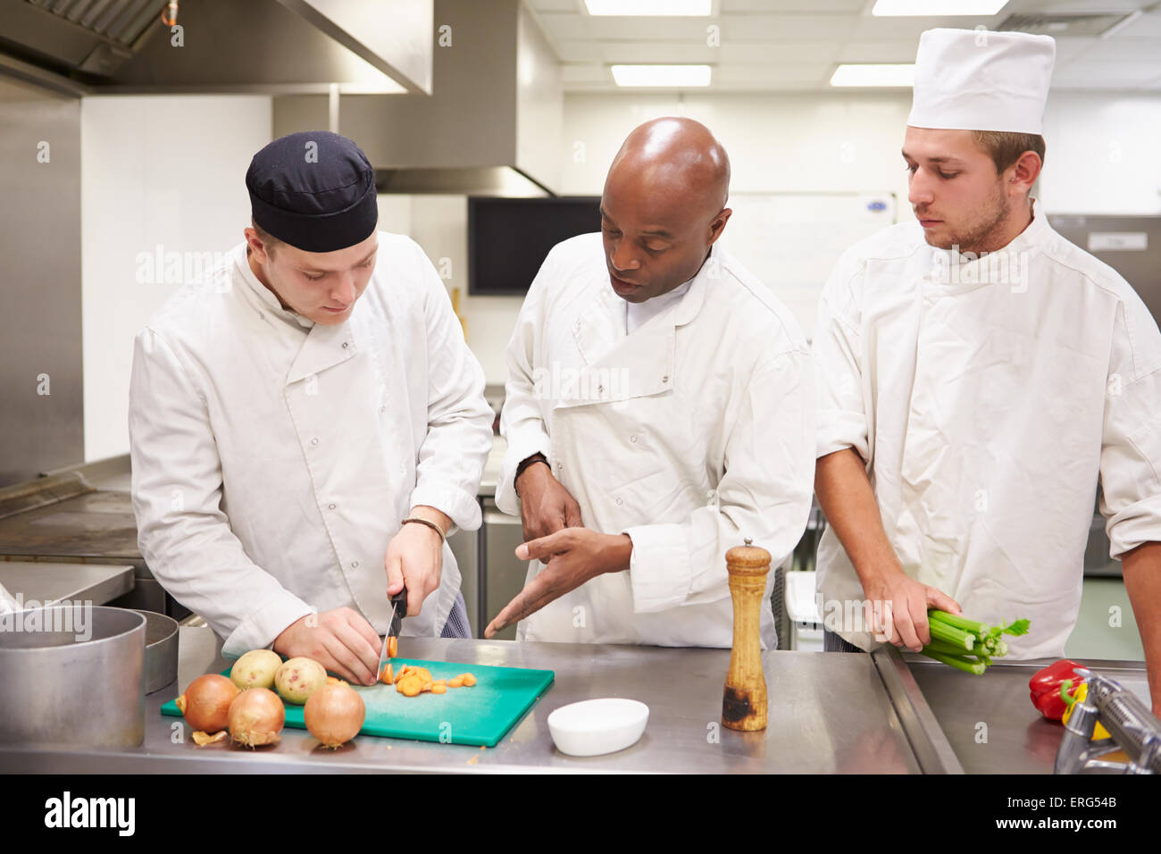 Teacher Helping Students Training To Work In Catering Stock Photo - Alamy