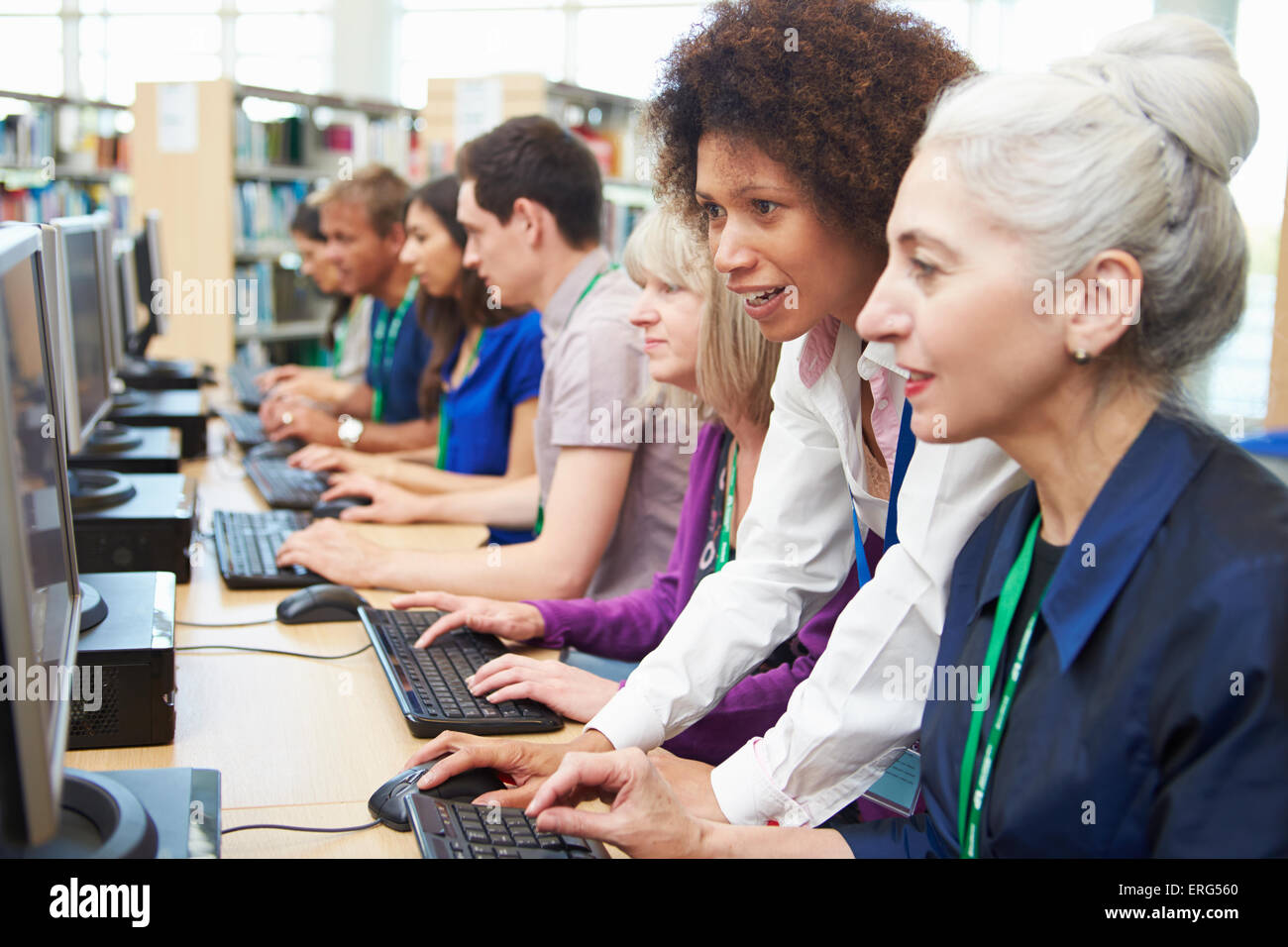 Group Of Mature Students Working At Computers With Tutor Stock Photo ...