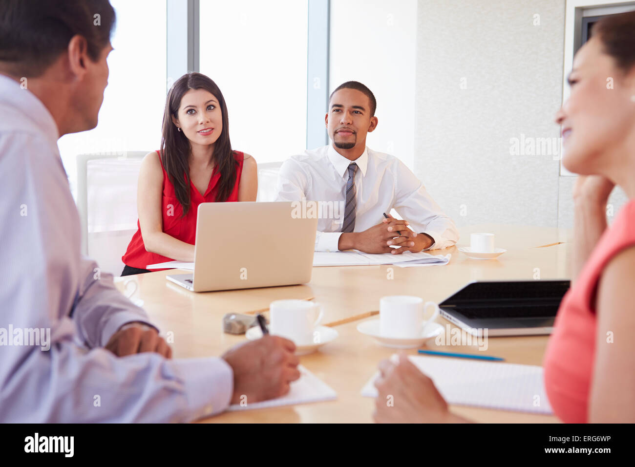 Four Hispanic Businesspeople Having Meeting In Boardroom Stock Photo ...