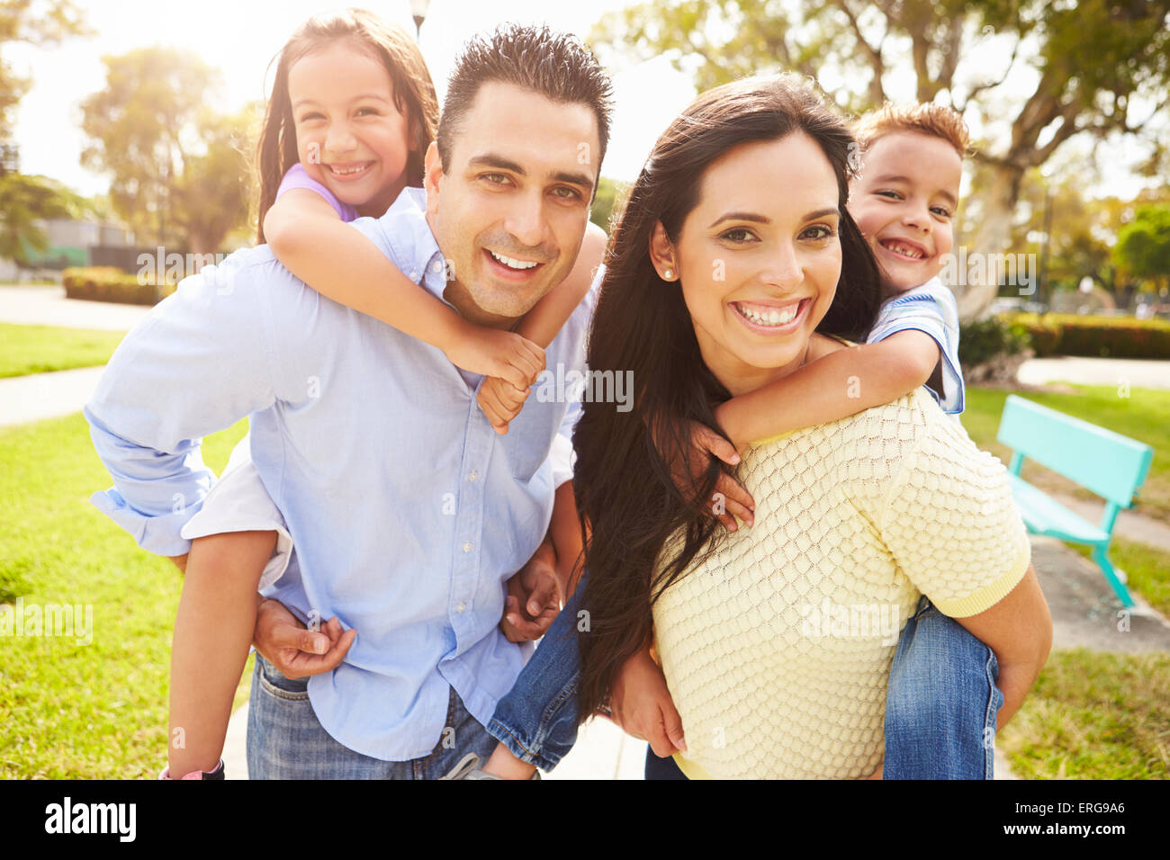 Parents Giving Children Piggyback Ride In Garden Stock Photo - Alamy