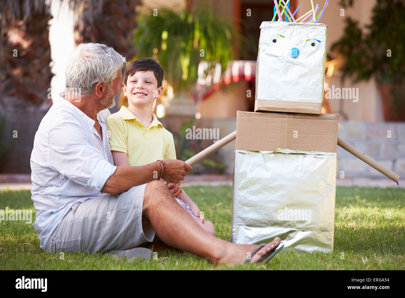 Grandfather And Grandson Building Model Robot In Garden Stock Photo - Alamy
