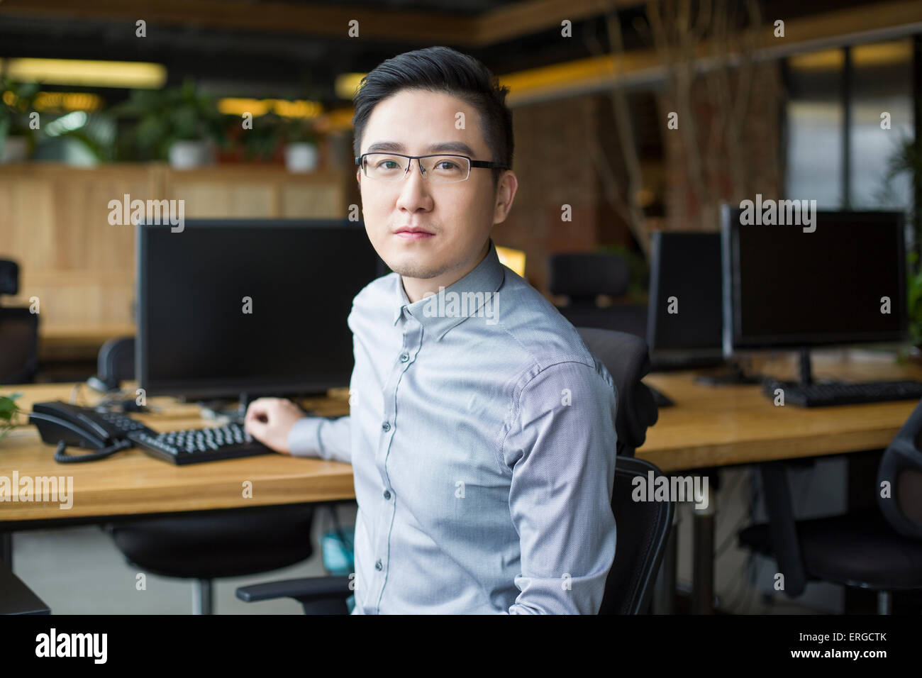 IT worker sitting in office Stock Photo - Alamy