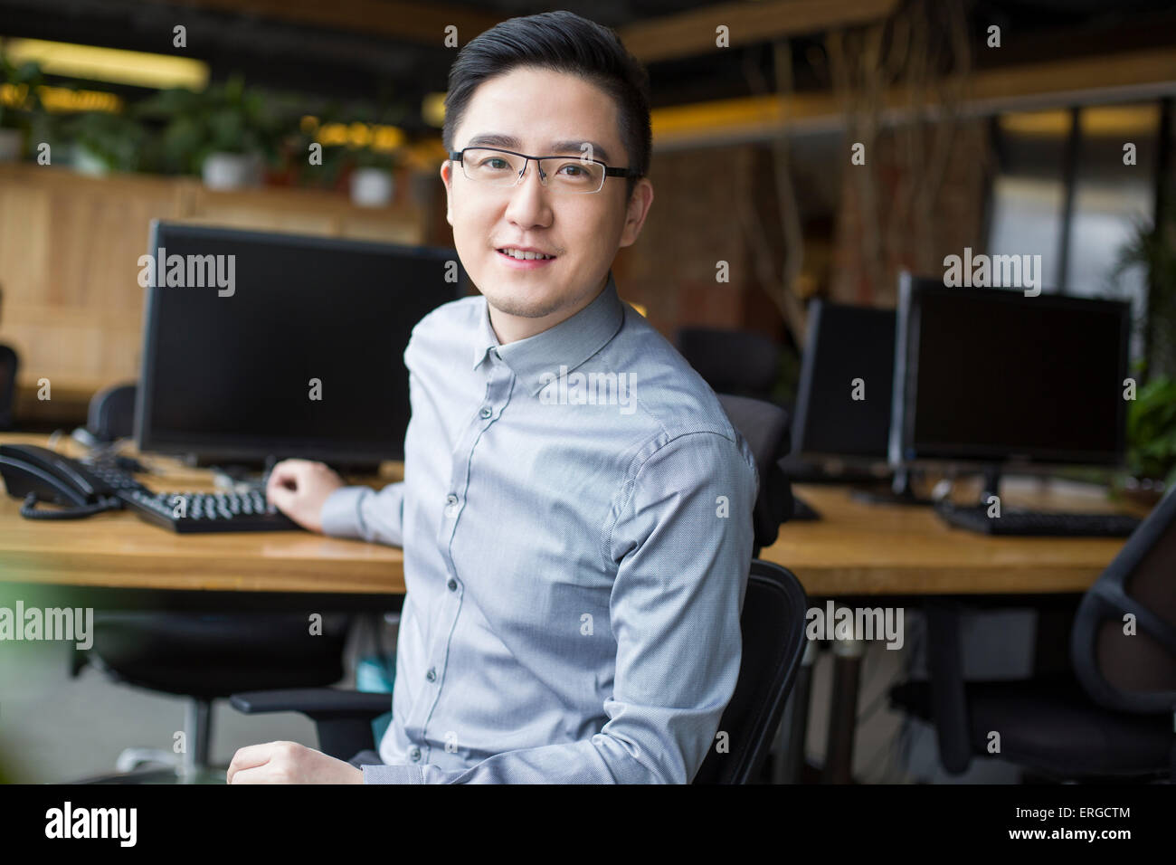 IT worker sitting in office Stock Photo - Alamy