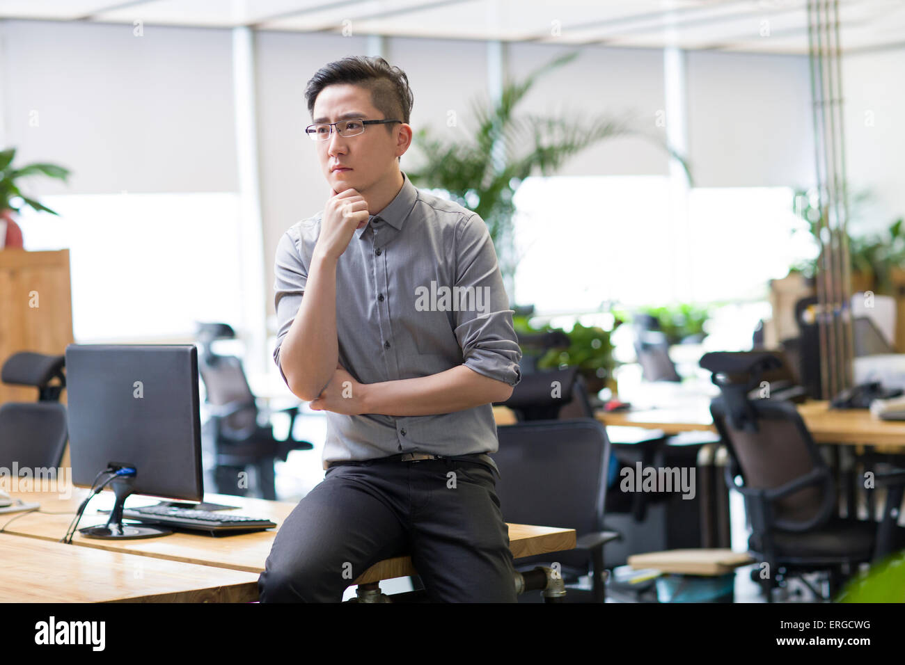IT worker thinking in office Stock Photo - Alamy