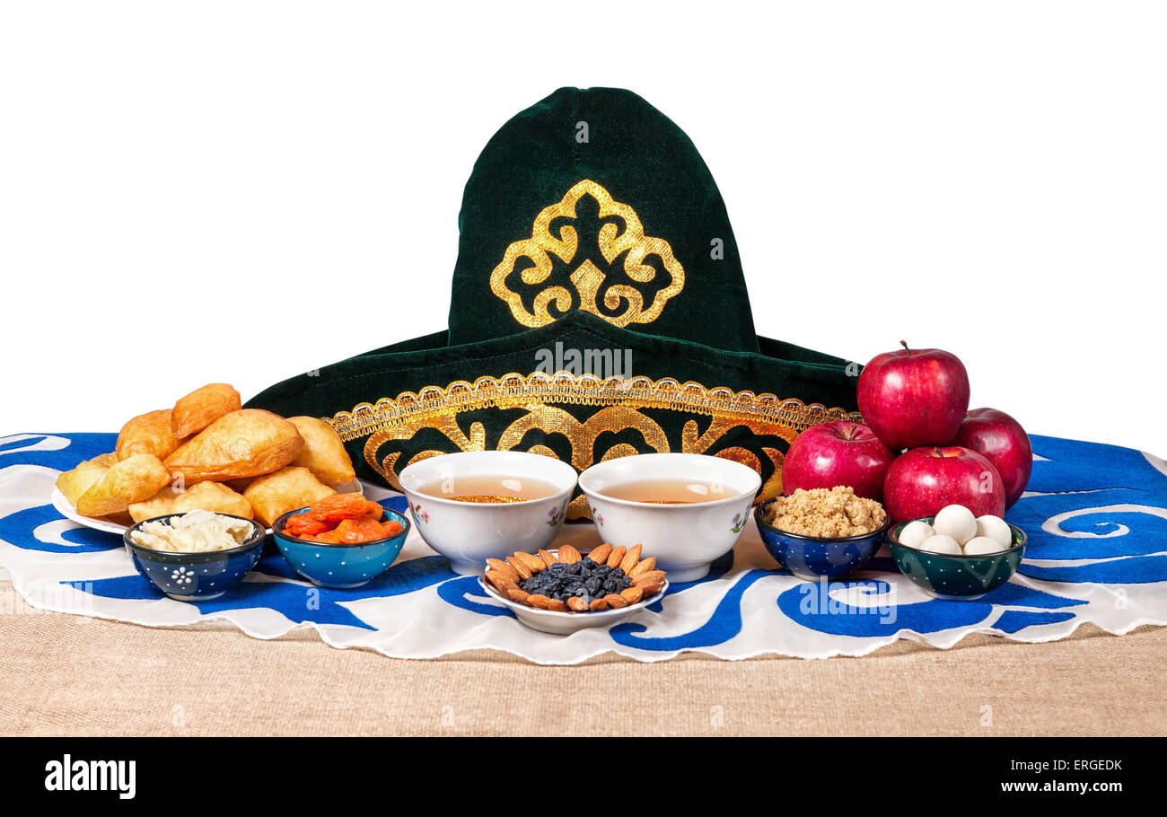 Kazakh national food on the table with national hat and tea at white ...