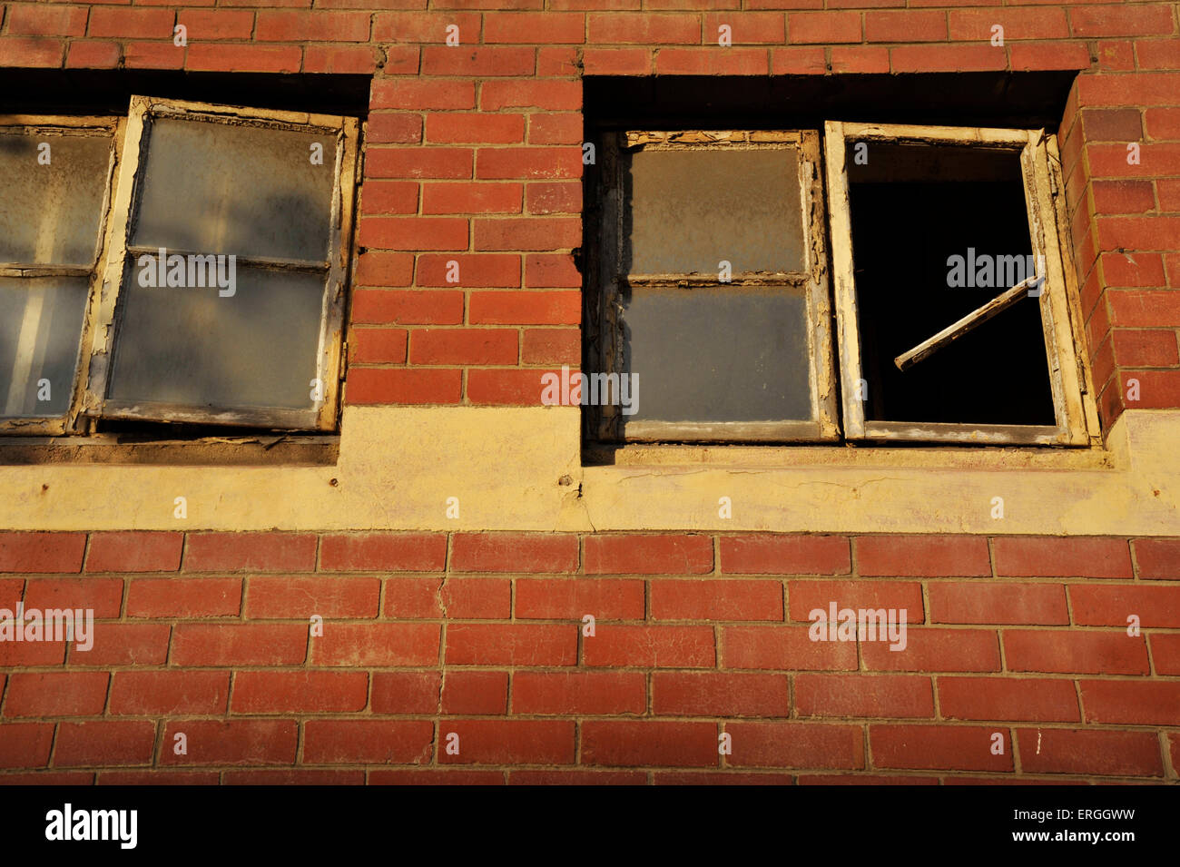 Rusting broken glass windows in abandoned red brick building Stock ...