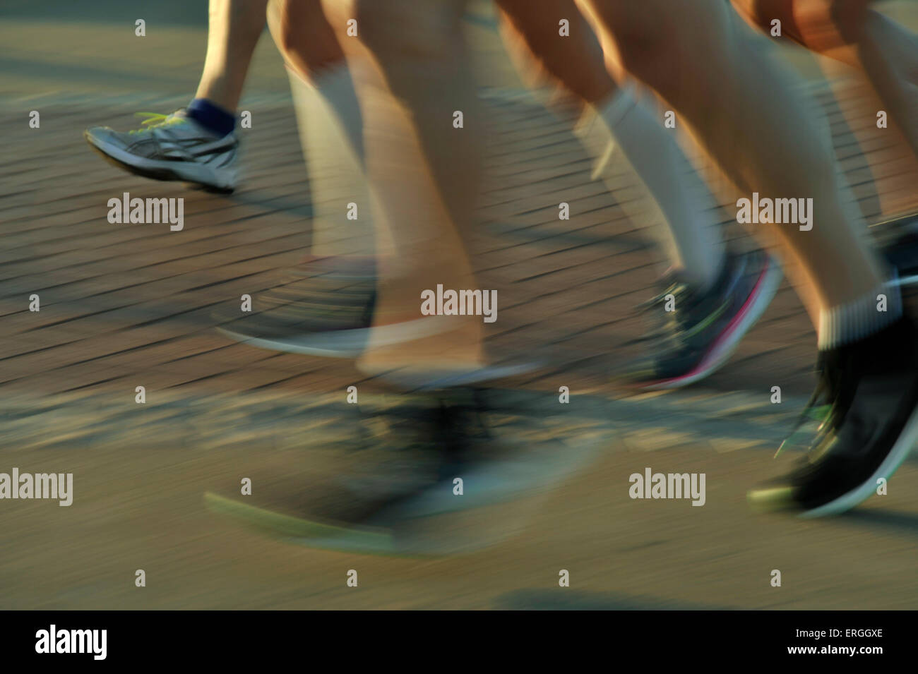Running shoes on blurred fast moving feet of adult women runners taking ...