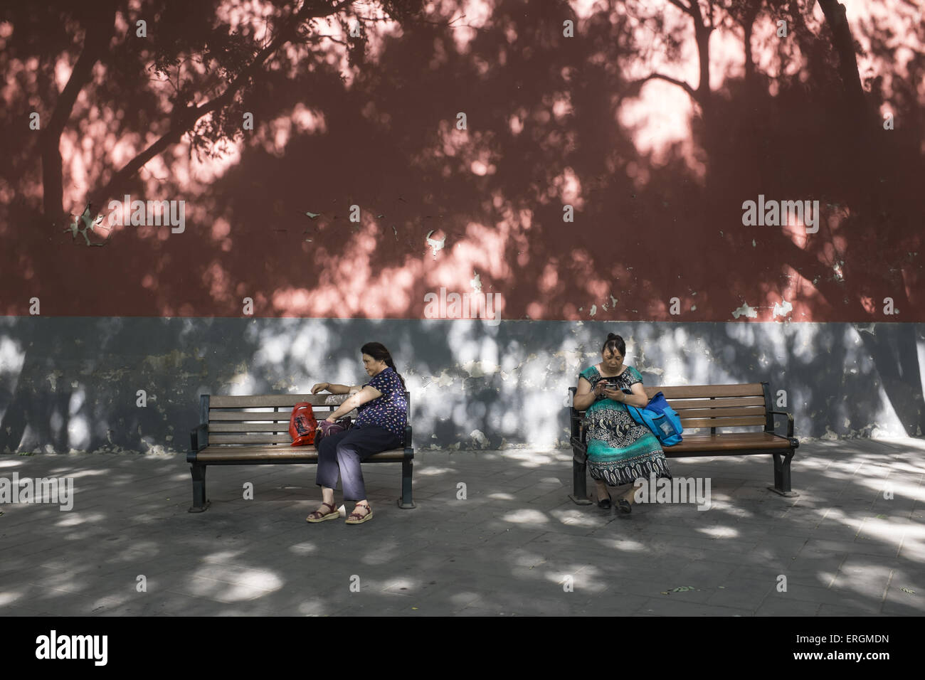 June 3, 2015 - two women sit on benchs at Beihai Park, Beijing, China ...