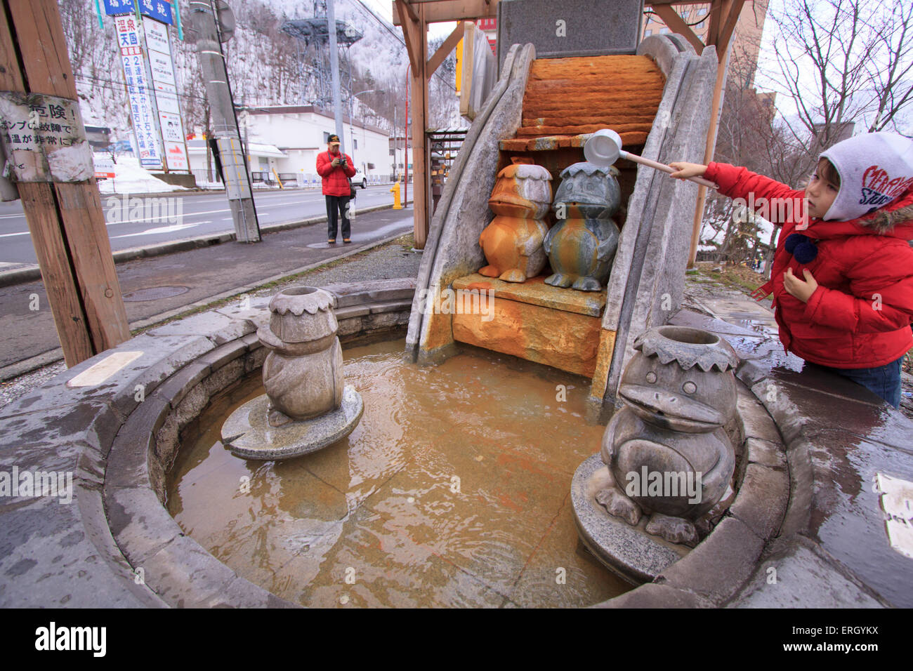 A young boy pours water to spill out of the mouth of a Kappa, water ...