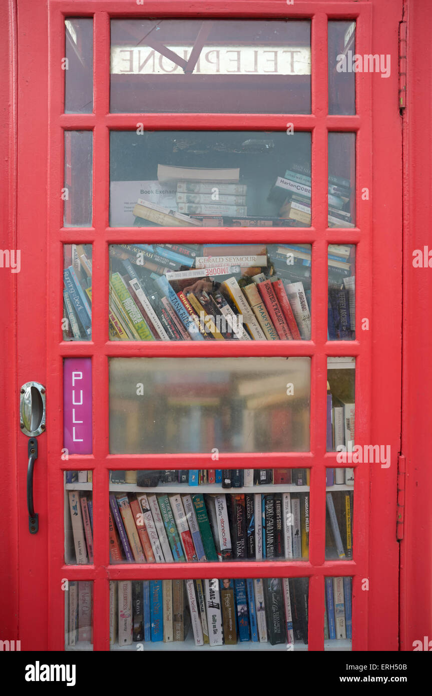 Public telephone box used as a book exchange or library in the village ...