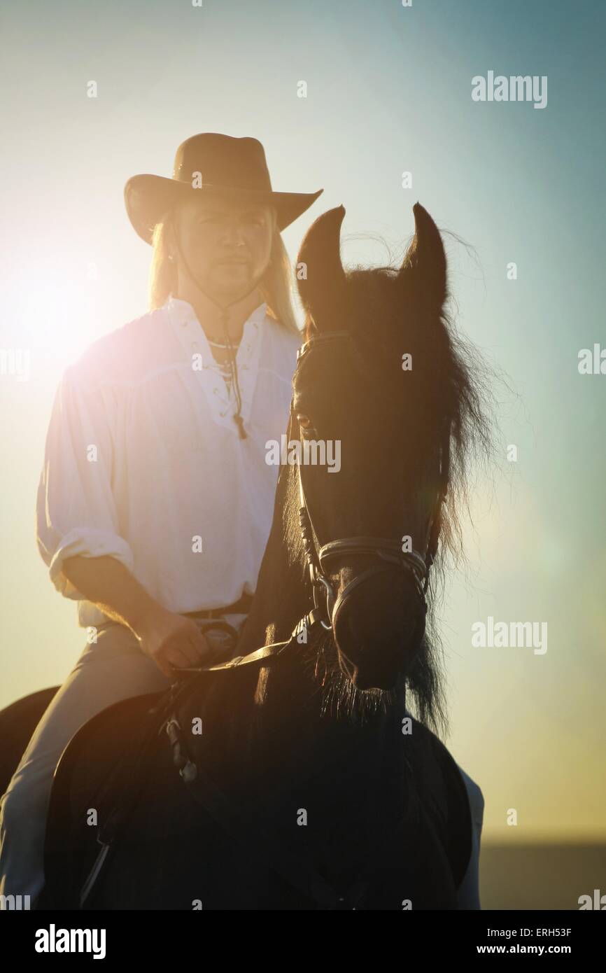 man rides Frisian horse Stock Photo - Alamy