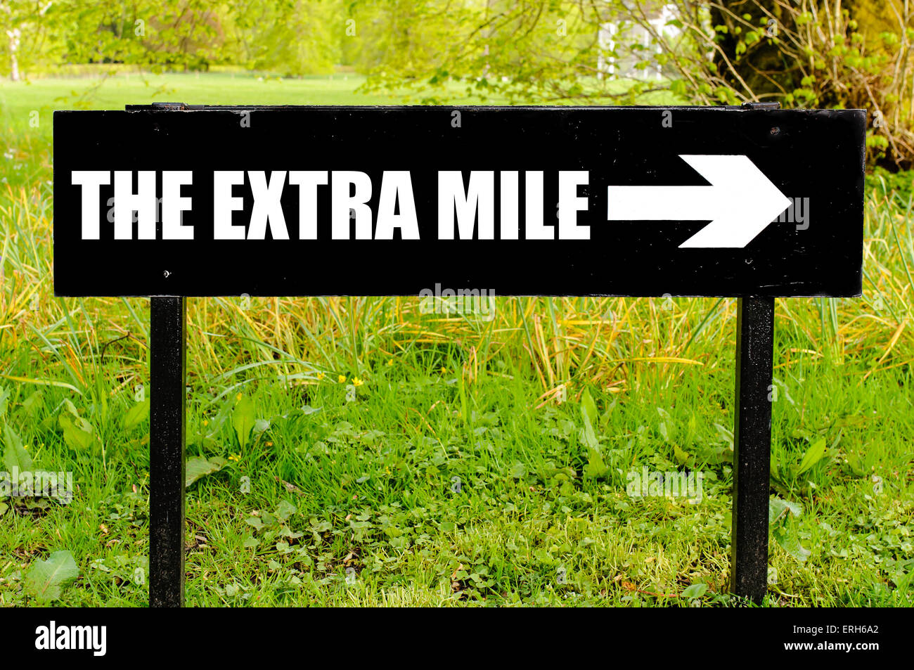 THE EXTRA MILE written on directional black metal sign with arrow ...