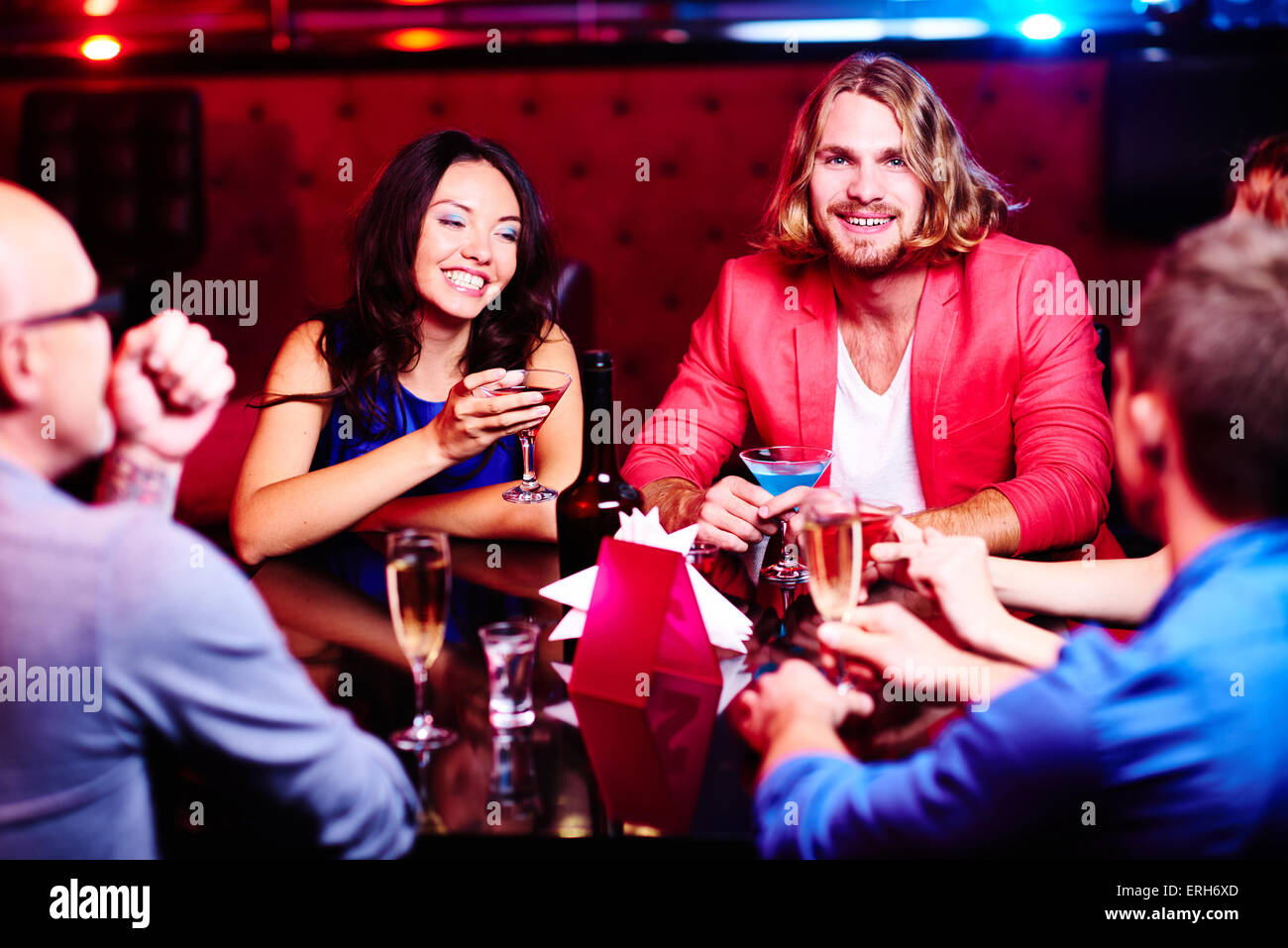 Group of happy friends sitting by table at restaurant Stock Photo - Alamy