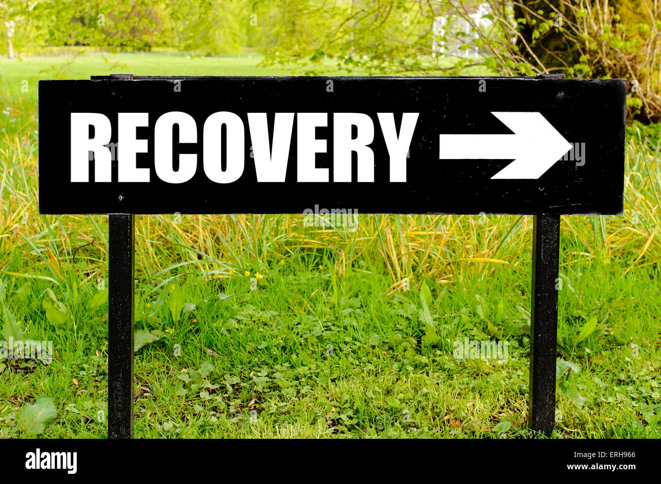 RECOVERY written on directional black metal sign with arrow pointing to ...