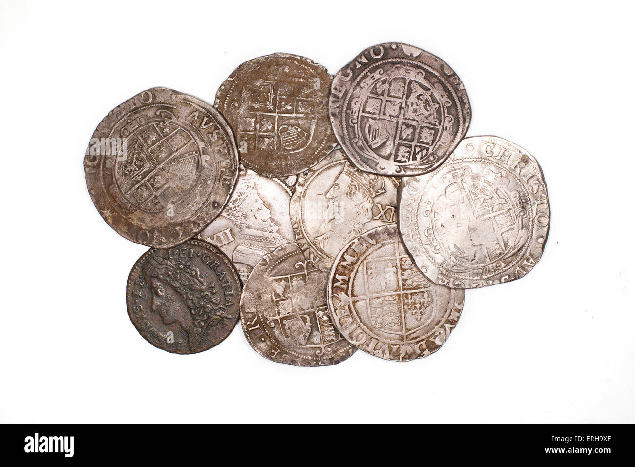A lot of old silver coins with portraits of kings on a white background ...