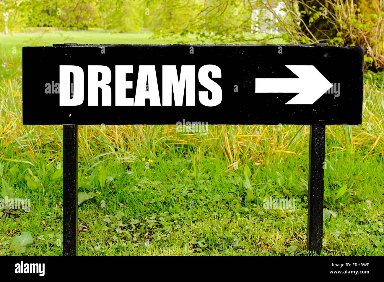 DREAMS written on directional black metal sign with arrow pointing to ...