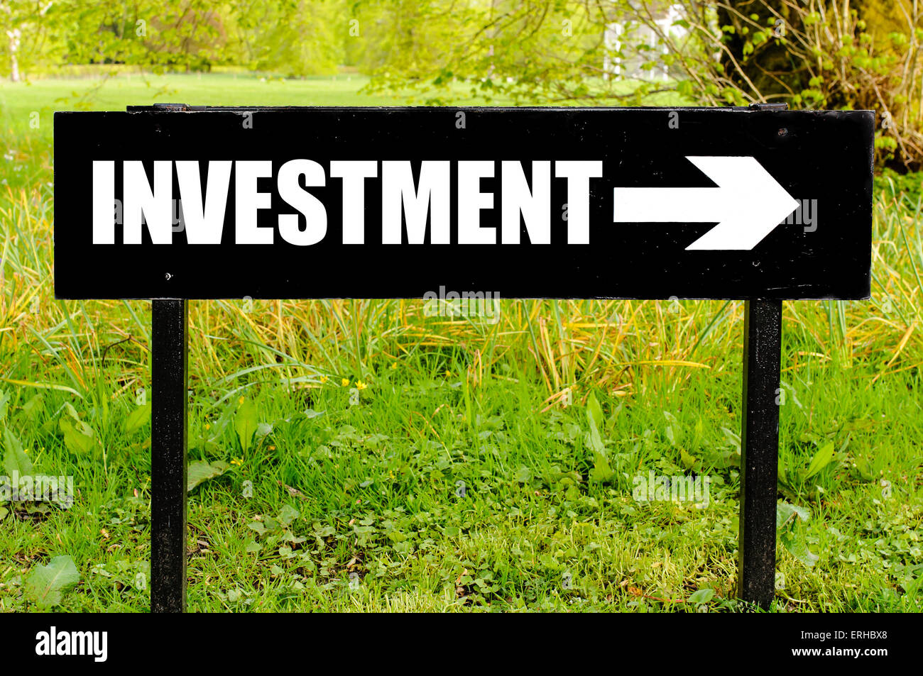 INVESTMENT written on directional black metal sign with arrow pointing ...