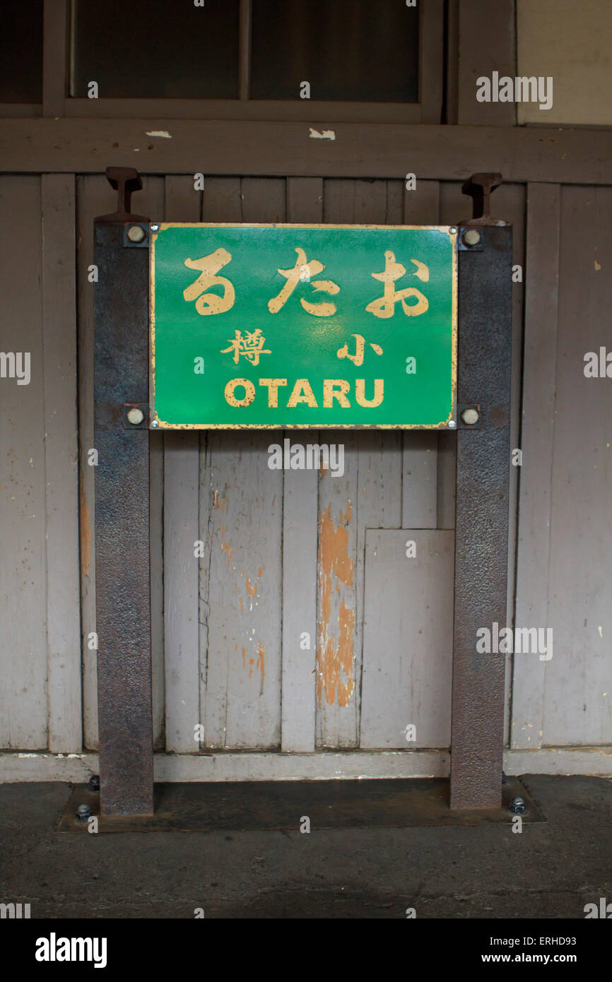 An old station sign, read right to left, marks the train station at ...