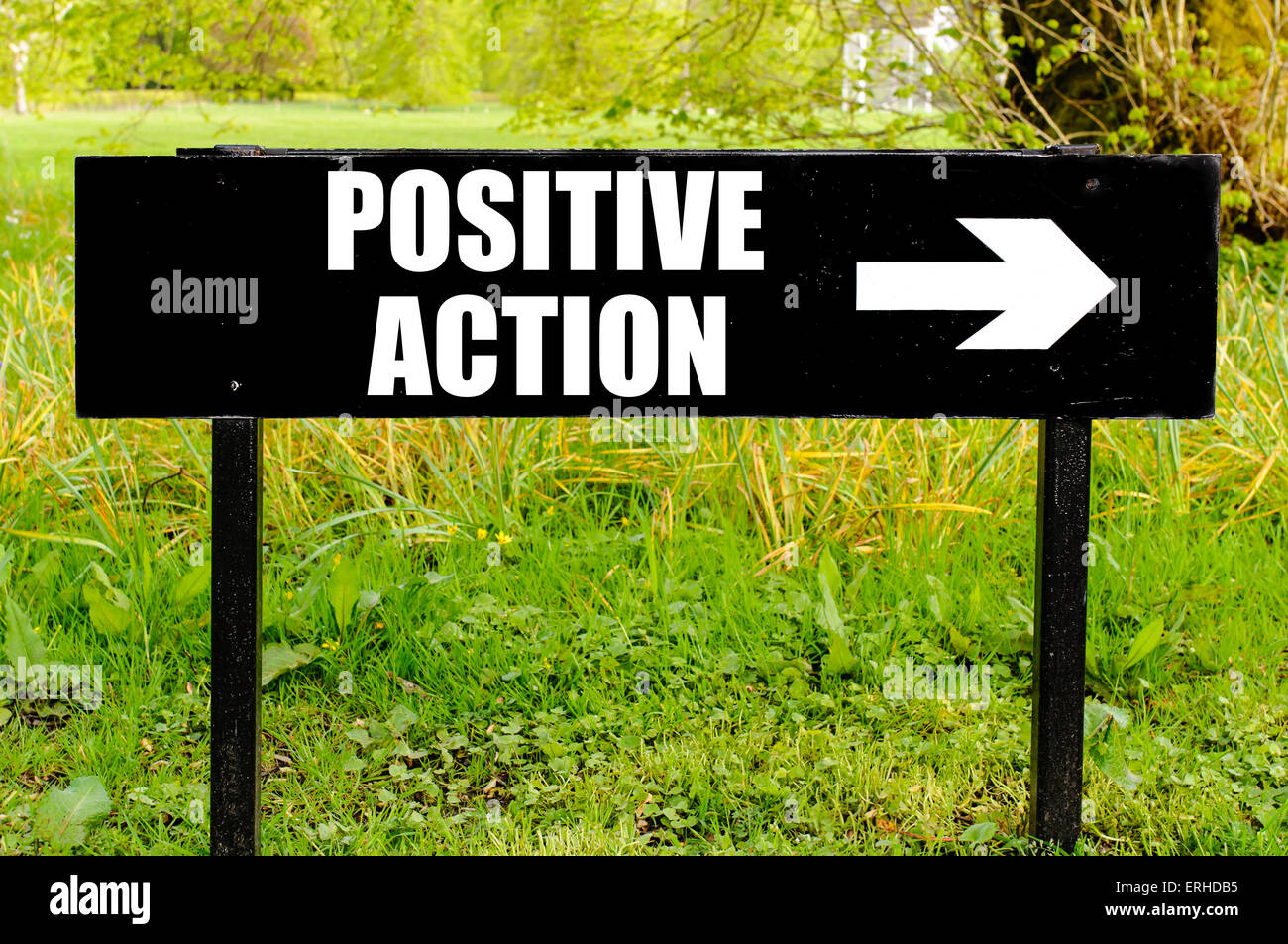 POSITIVE ACTION written on directional black metal sign with arrow ...