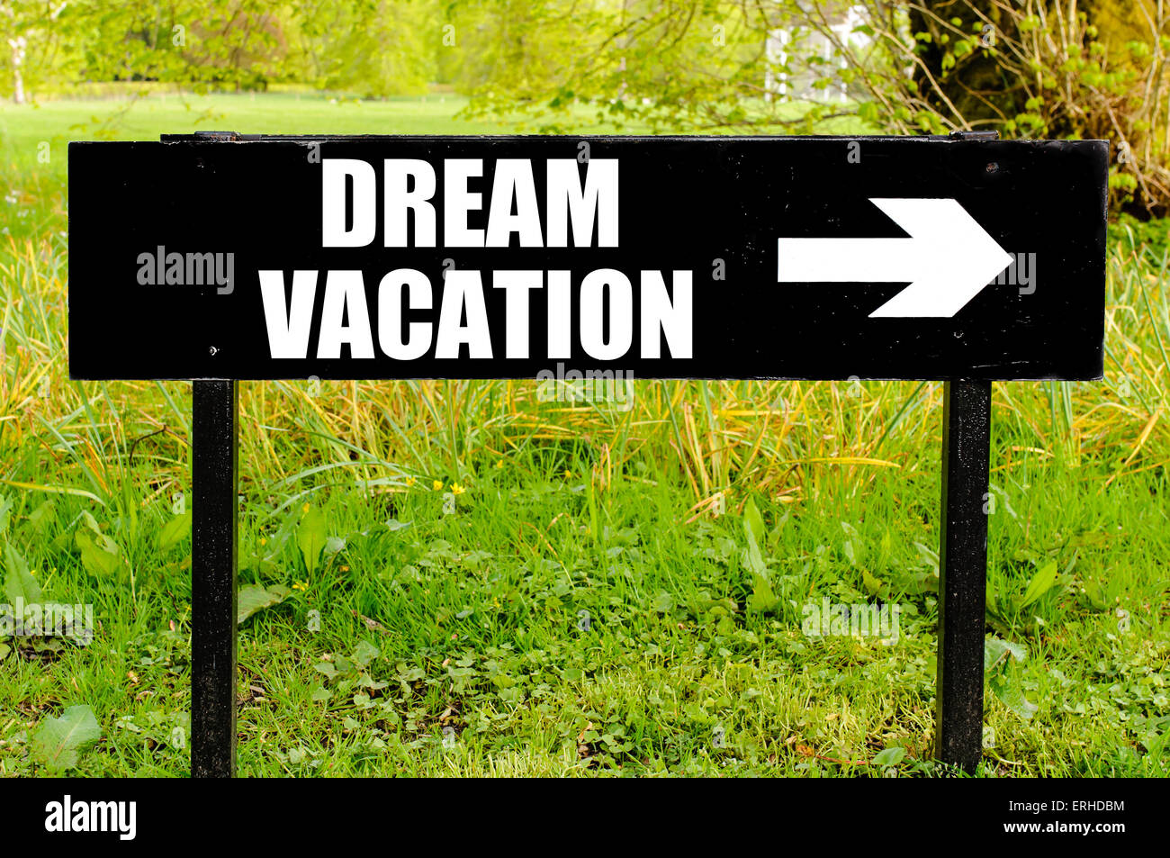 DREAM VACATION written on directional black metal sign with arrow ...