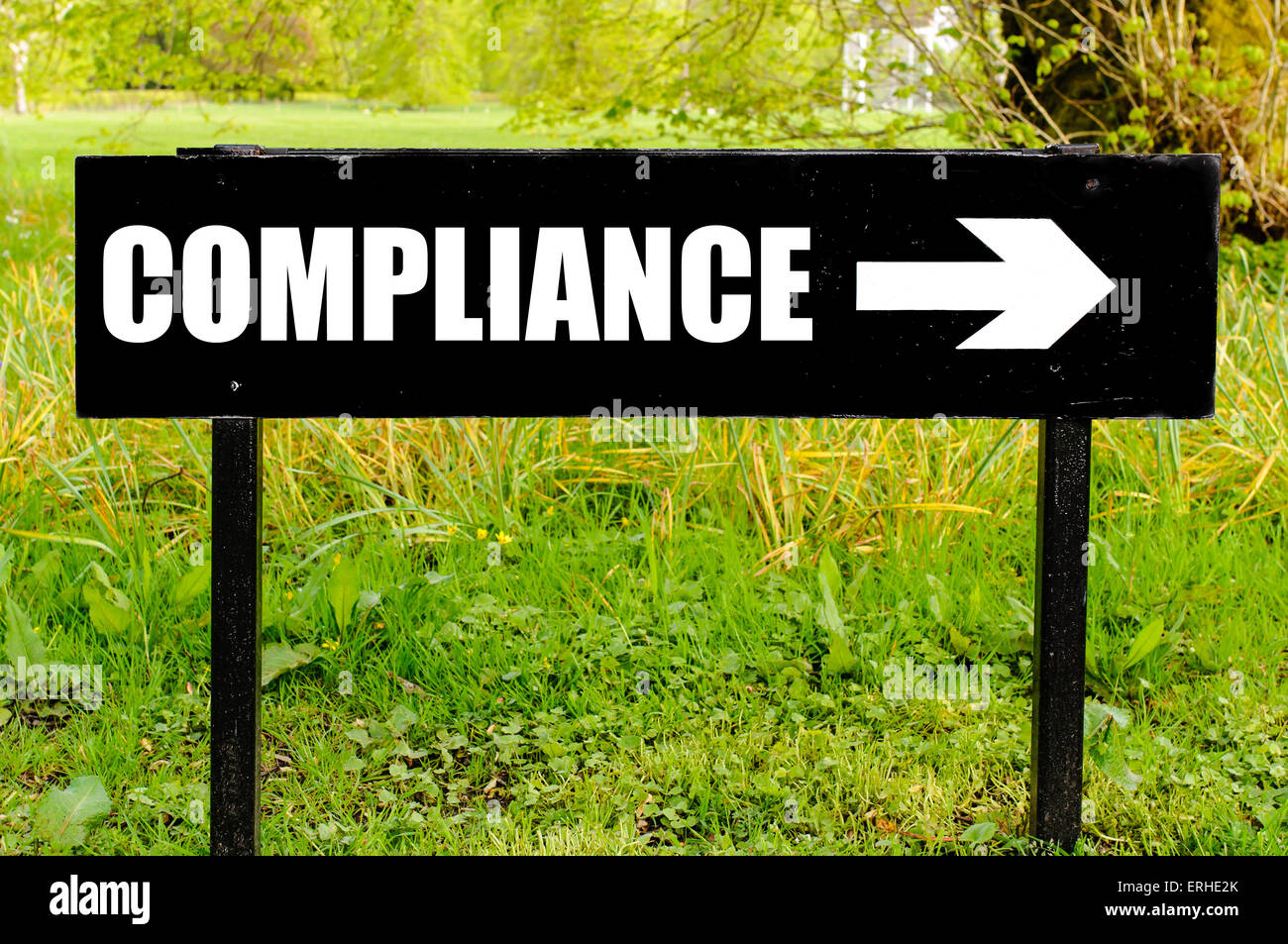 COMPLIANCE written on directional black metal sign with arrow pointing ...