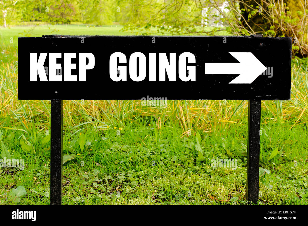 KEEP GOING written on directional black metal sign with arrow pointing ...